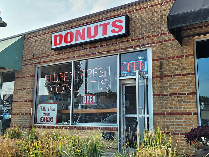 The brick facade and neon sign of Fluffy Fresh Donuts stands as a beacon of sweet promises on Johnson Drive. Mission accomplished!