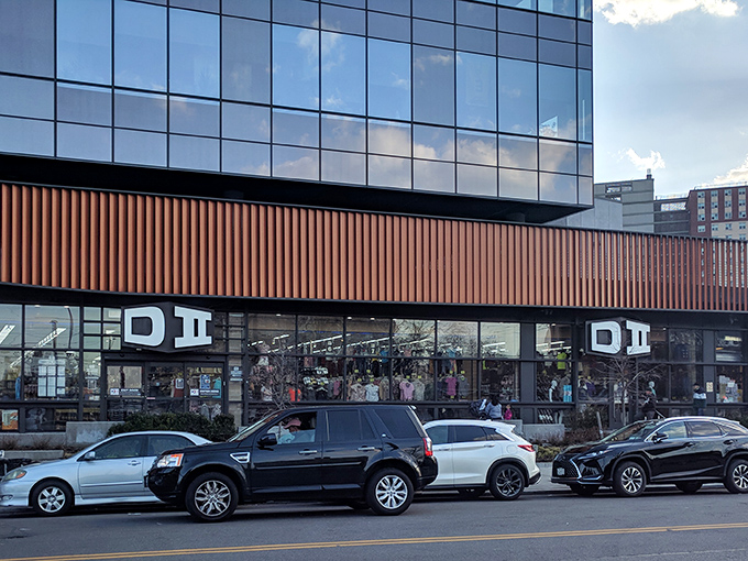 The distinctive orange-trimmed exterior of DII beckons bargain hunters like a retail oasis in Sheepshead Bay, complete with patriotic bunting and clearance promises.