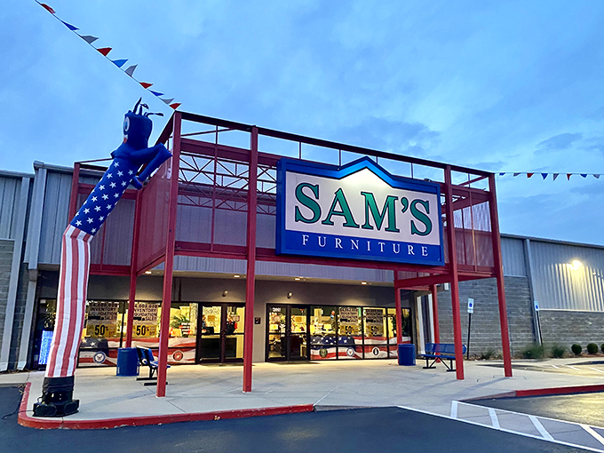 The iconic red entrance of Sam's Furniture stands out like a Broadway marquee, complete with a patriotic inflatable tube man welcoming shoppers to the furniture wonderland.