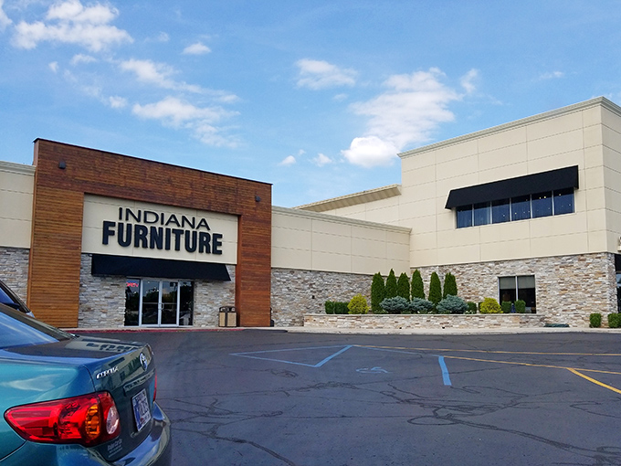 The modern exterior blends warm wood paneling with stone accents, creating a fa&ccedil;ade that says "Yes, I'm a furniture store, but I've got style."