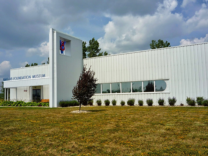 A gleaming 1936 Ford sedan poses like a silver screen starlet against the museum's distinctive white architecture. Automotive time travel at its finest.