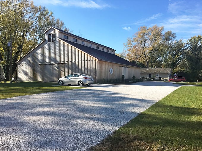 The Classic Motor Museum's weathered barn exterior houses automotive treasures inside, while a cherry-red Alfa Romeo Spider teases what awaits curious visitors.