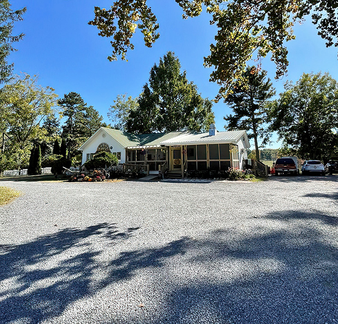 A storybook cottage nestled among towering trees, The Hatter Caf&eacute;'s charming exterior promises whimsical adventures before you even step inside.