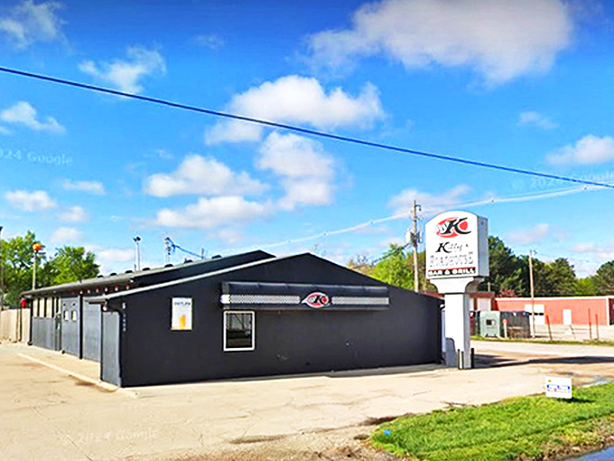 The unassuming black exterior of Kitty's Roadhouse stands like a culinary oasis in Hastings, promising roadside delights that Nebraska locals have treasured for years.