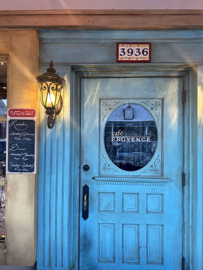 The iconic blue door of Caf&eacute; Provence beckons like a portal to southern France, complete with charming oval window and vintage lantern. Step through and prepare for culinary time travel.