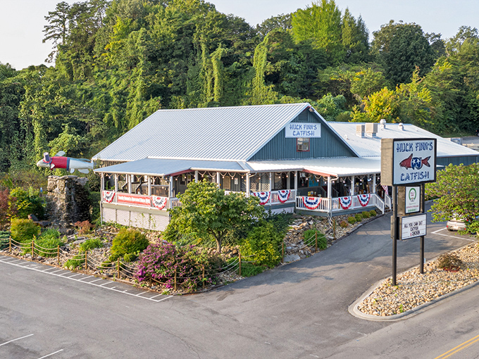 The unassuming exterior of Huck Finn's Catfish stands like a humble guardian of flavor, promising Southern comfort beneath its metal roof and welcoming porch.