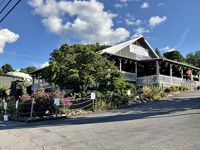 The unassuming exterior of Huck Finn's Catfish stands like a humble guardian of flavor, promising Southern comfort beneath its metal roof and welcoming porch.