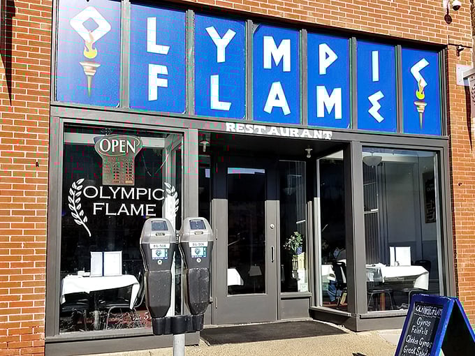The blue signage of Olympic Flame beckons like a Mediterranean lighthouse amid Des Moines' brick buildings. Greek cuisine awaits!