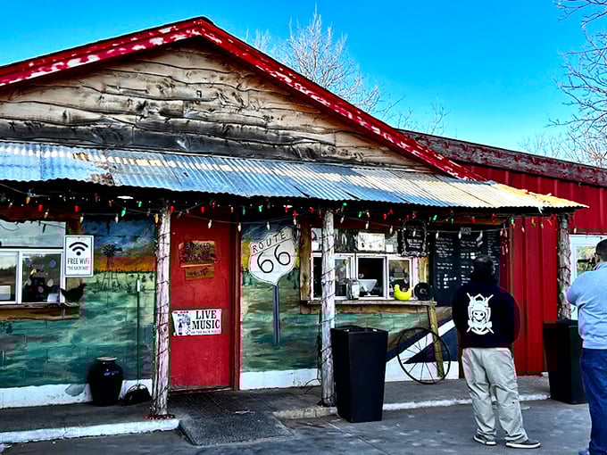 Route 66 nostalgia meets finger-lickin' reality at this weathered roadside gem. The red door practically winks at you, promising delicious secrets inside.