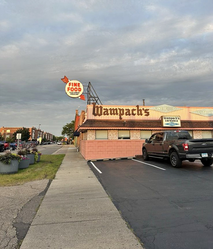 The pink brick facade of Wampach's stands like a time capsule, promising "FINE FOOD" with the confidence of someone who's been keeping that promise for decades.