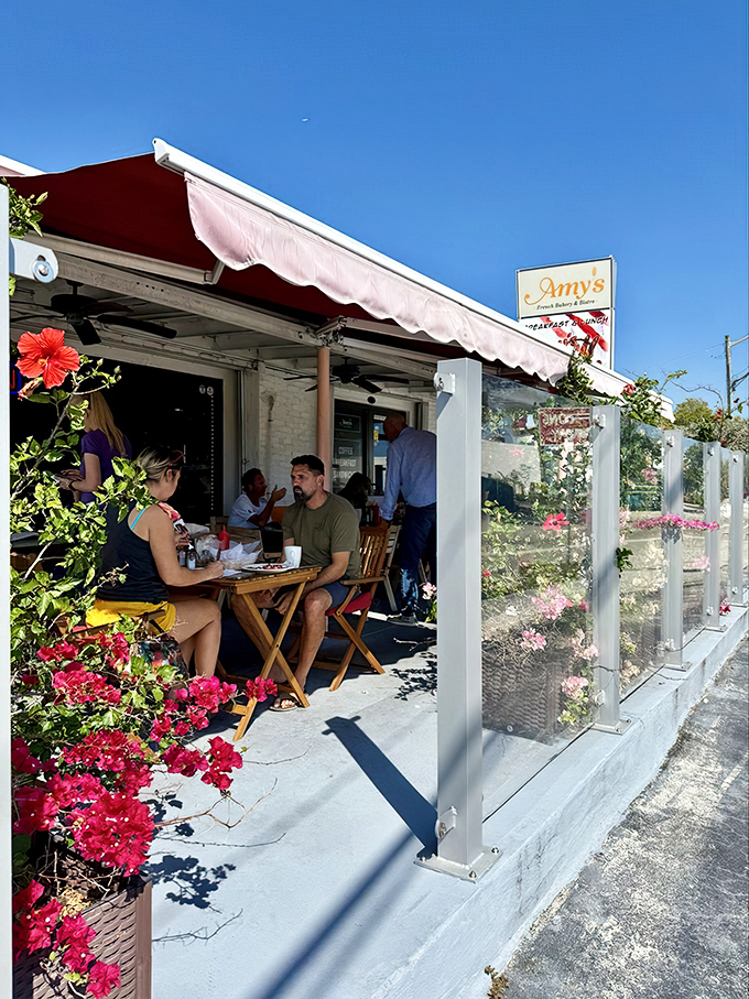 Amy's charming exterior welcomes you with a splash of European flair. Those red awnings and potted flowers aren't just decoration&mdash;they're a promise of the warmth waiting inside.