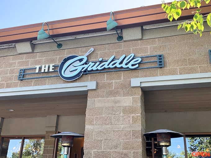 The stylish exterior of The Griddle beckons with its warm stone facade and signature blue lamps&mdash;breakfast paradise hiding in plain sight.