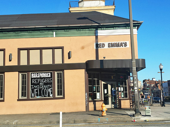 The iconic red brick exterior of Red Emma's stands as Baltimore's literary lighthouse, beckoning bibliophiles and coffee enthusiasts alike since 2004.