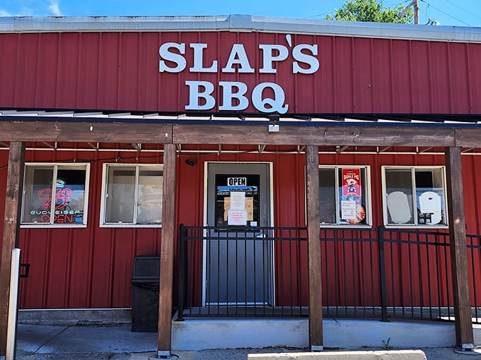 The iconic red exterior of Slap's BBQ stands as a beacon of hope for hungry pilgrims seeking smoky salvation in Kansas City's competitive barbecue landscape.