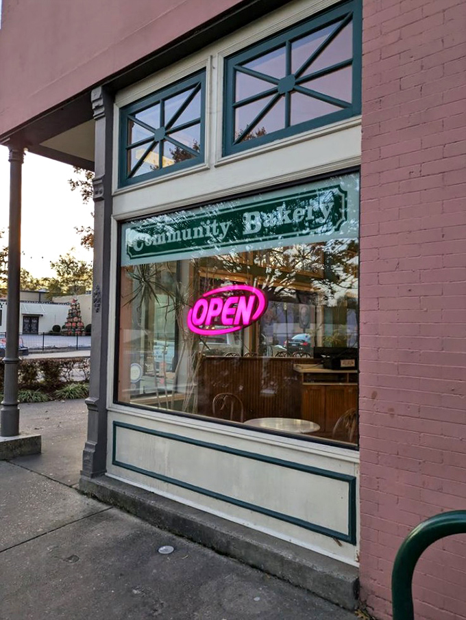The iconic teal-trimmed entrance of Community Bakery beckons like an old friend, promising carb-laden treasures behind that glowing "OPEN" sign.