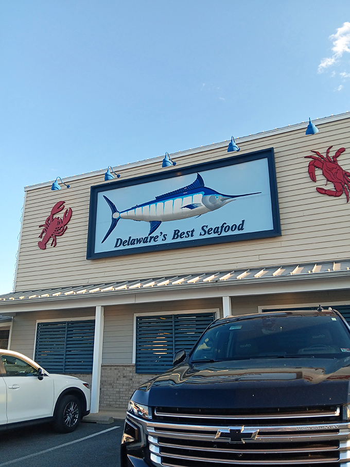 The blue and white checkered sign beckons like a coastal lighthouse, promising seafood treasures within this unassuming Rehoboth Beach institution.