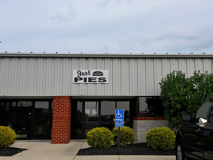 The unassuming exterior of Just Pies belies the magic happening inside. Like finding a treasure chest disguised as a storage shed.