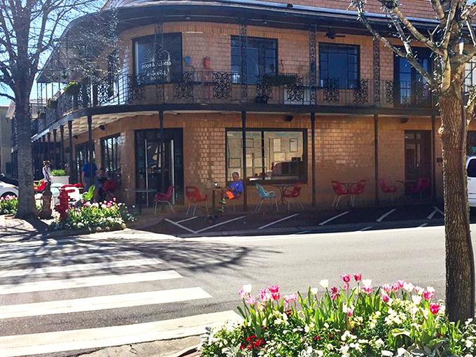 The iconic brick exterior of Page & Palette stands like a literary lighthouse on Fairhope's corner, beckoning bookworms with its New Orleans-inspired balconies.