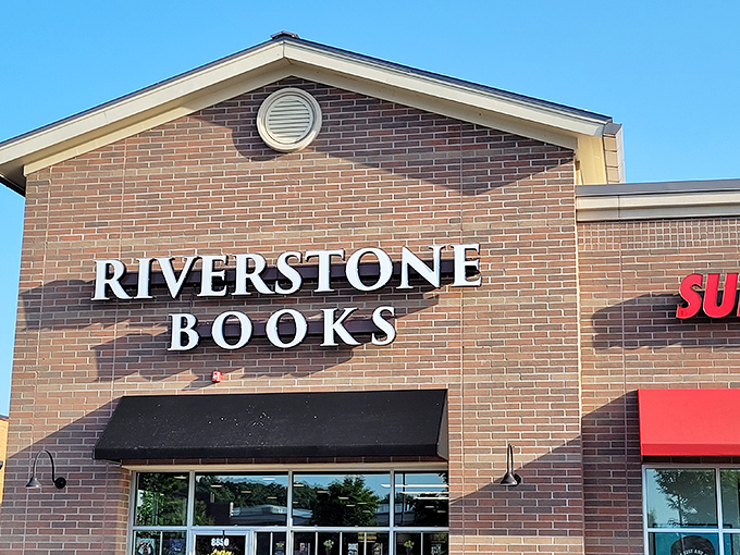 The brick fa&ccedil;ade of Riverstone Books stands like a literary lighthouse, beckoning bibliophiles with its simple, elegant signage against the blue Pittsburgh sky. 
