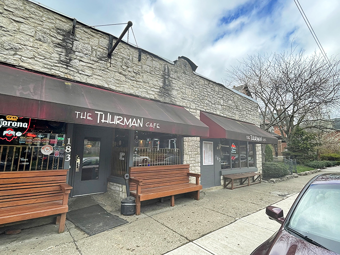 The unassuming stone exterior with its crimson awning doesn't scream "burger legend," but the wooden benches outside hint at something worth waiting for.