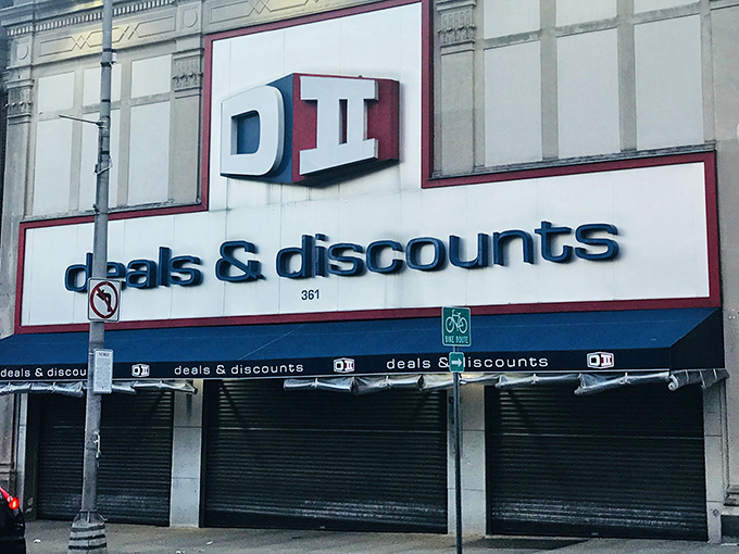 The blue and red signage of DII Deals & Discounts beckons like a siren song to bargain hunters navigating the urban landscape of Jersey City.