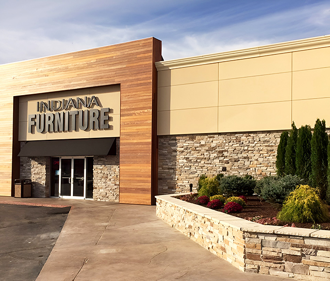 The modern exterior blends warm wood paneling with stone accents, creating a fa&ccedil;ade that says "Yes, I'm a furniture store, but I've got style."