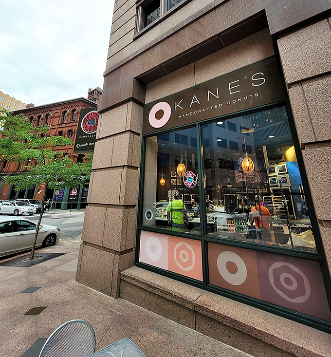 Kane's iconic storefront in Boston's Financial District beckons like a pink-glazed lighthouse to donut lovers navigating the urban sea of steel and stone.
