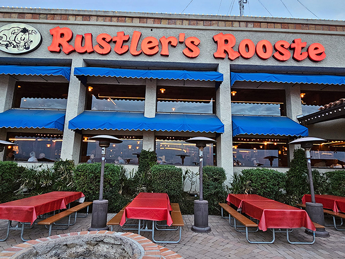 The welcoming facade of Rustler's Rooste stands proud against the Arizona sky, where blue awnings and red tablecloths hint at the Western hospitality waiting inside.