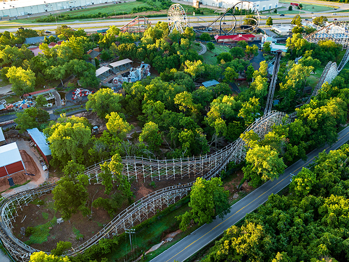 A bird's-eye view reveals Frontier City's wooden roller coaster snaking through lush greenery, proving thrills and nature can coexist beautifully in Oklahoma City.