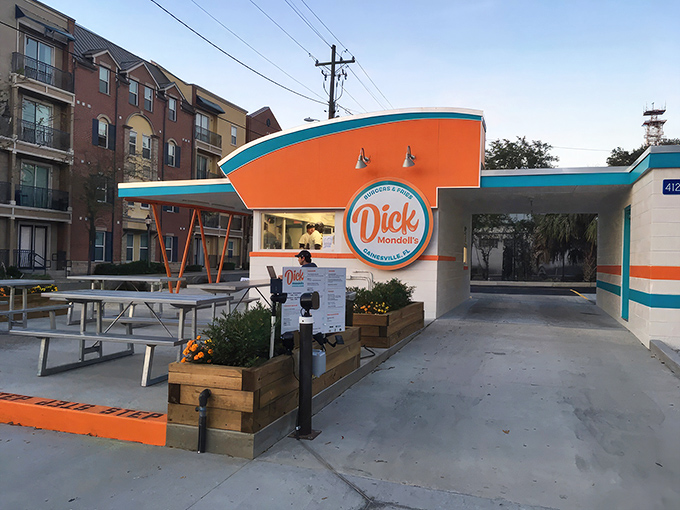 The bright orange and turquoise exterior isn't just eye-catching—it's a siren call to burger lovers everywhere. Florida sunshine and shade umbrellas complete the perfect dining setup.
