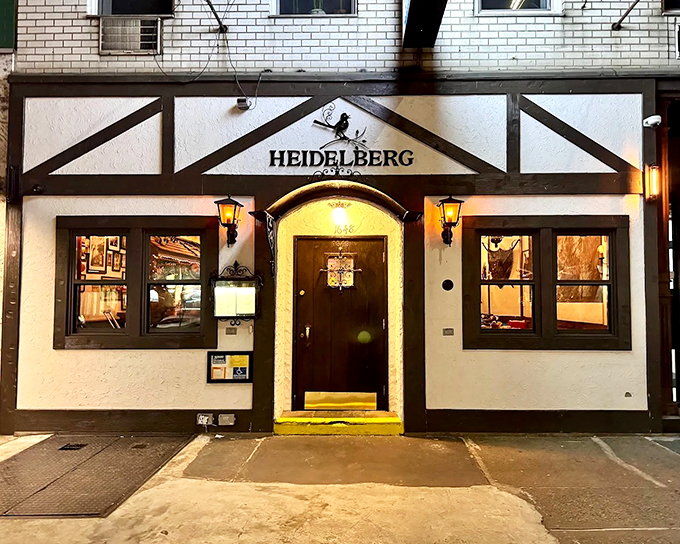 The storybook facade of Heidelberg Restaurant beckons with its warm yellow glow, promising Bavarian magic in the heart of Manhattan's concrete jungle.