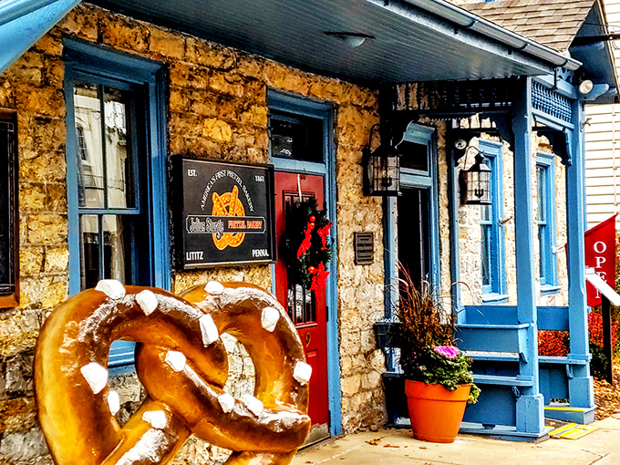 A stone and brick facade with bright blue trim and welcoming red doors &ndash; Julius Sturgis stands as a beacon of pretzel perfection in charming Lititz.
