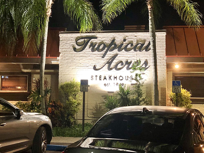 The iconic white brick fa&ccedil;ade of Tropical Acres glows invitingly at night, palm trees standing guard like old friends welcoming you home.