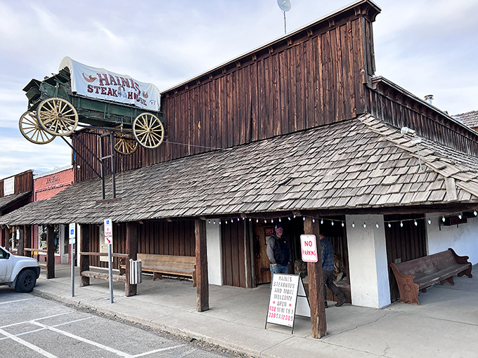 The wagon on the roof isn't just decoration &ndash; it's a beacon for hungry travelers. This rustic wooden exterior promises authentic Western dining experiences inside.