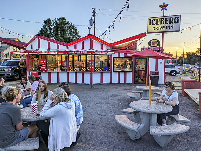 The iconic red and white striped exterior of Iceberg Drive Inn stands like a time capsule on 3900 South, promising nostalgic delights within.