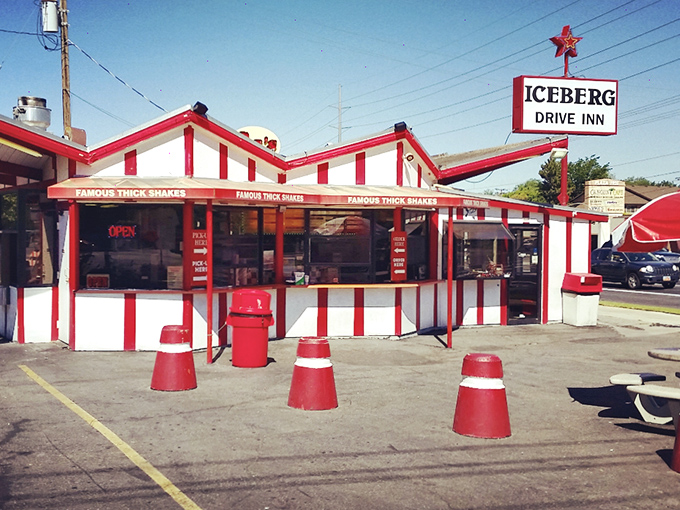 The iconic red and white striped exterior of Iceberg Drive Inn stands like a time capsule on 3900 South, promising nostalgic delights within.