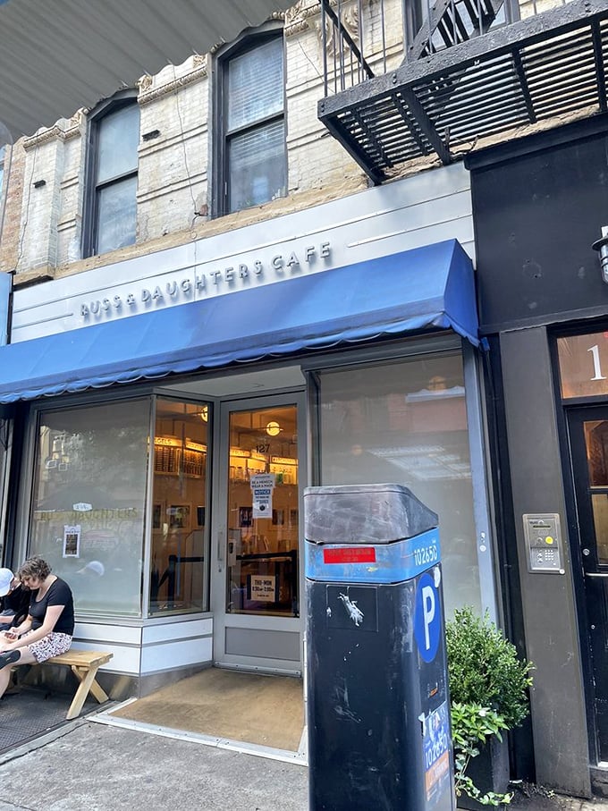 The iconic blue awning of Russ & Daughters Cafe stands out like a culinary lighthouse, guiding hungry souls to this Lower East Side institution. 