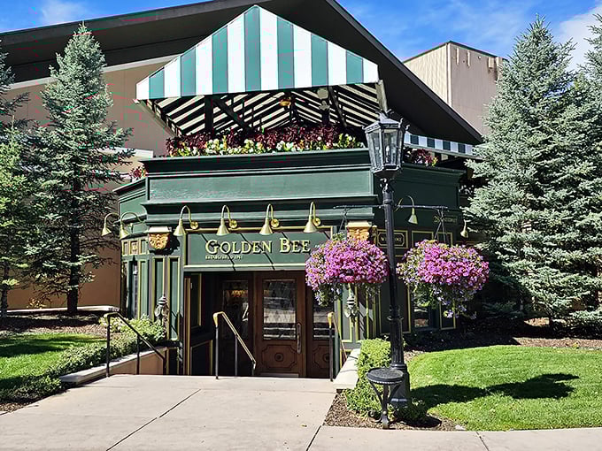 The emerald jewel of Colorado Springs beckons with its distinctive green and white awning, promising British comfort in the shadow of the Rockies.