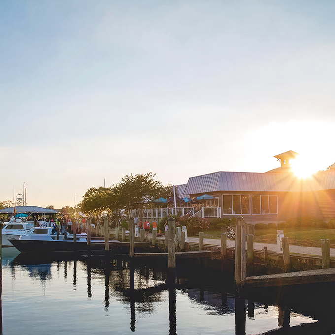 Brew River's weathered gray exterior with vibrant crape myrtle blooms creates the perfect first impression&mdash;nature's red carpet welcoming you to Eastern Shore dining excellence.