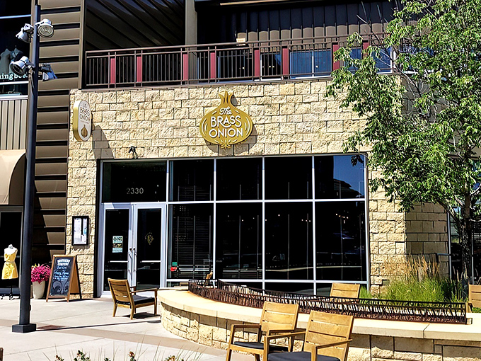 The Brass Onion's inviting exterior glows at twilight, with a cozy fire feature that practically whispers, "Come in and stay awhile."