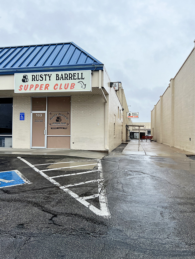 The unassuming entrance to Rusty Barrell Supper Club proves the old adage: never judge a steak by its storefront. That red bench? Your waiting room to carnivore heaven.