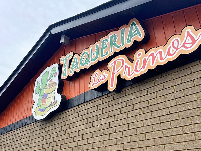 The unmistakable orange facade of Taqueria Los Primos stands out like a culinary lighthouse, beckoning hungry travelers with its colorful benches and promise of authentic flavors.