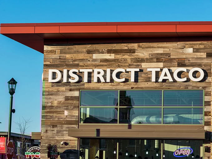The rustic wooden exterior of District Taco welcomes hungry visitors with its vibrant sign and colorful flower boxes&mdash;a taco oasis in King of Prussia.