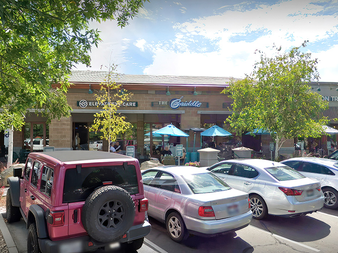 The stylish exterior of The Griddle beckons with its warm stone facade and signature blue lamps&mdash;breakfast paradise hiding in plain sight.