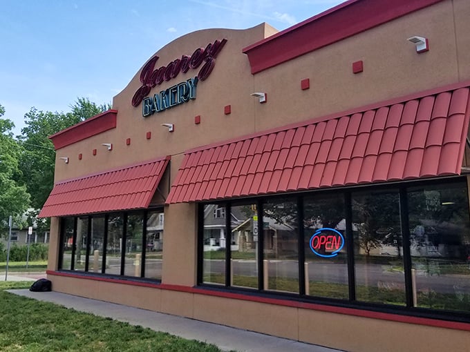 The tan building with striking red awnings beckons like a lighthouse for carb enthusiasts. One glance at that "OPEN" sign and resistance becomes futile.