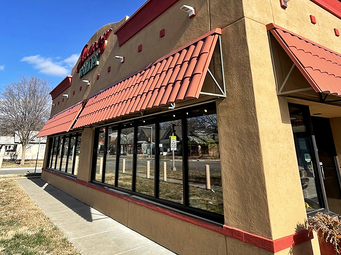 The tan building with striking red awnings beckons like a lighthouse for carb enthusiasts. One glance at that "OPEN" sign and resistance becomes futile.