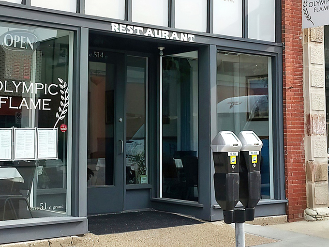 The blue signage of Olympic Flame beckons like a Mediterranean lighthouse amid Des Moines' brick buildings. Greek cuisine awaits!