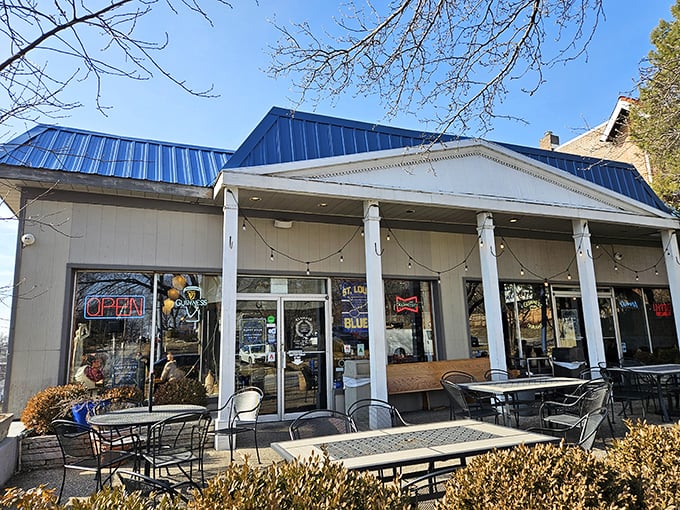 A Mediterranean oasis awaits behind leafy sentinels. Olympia's inviting blue-and-white patio beckons passersby to escape the Missouri heat for a Grecian retreat.