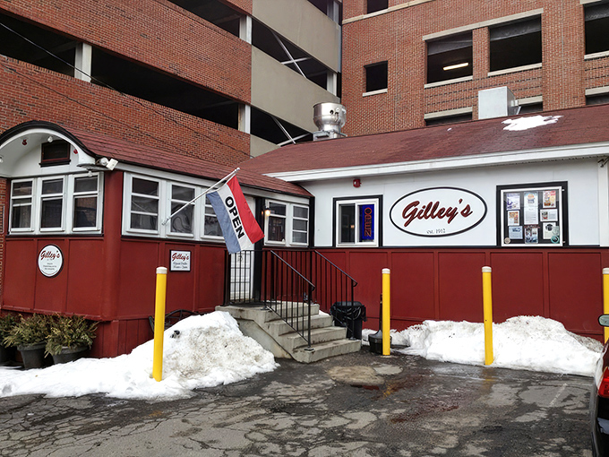 A humble red and white diner nestled against a parking garage&mdash;proof that culinary treasures often hide in plain sight.