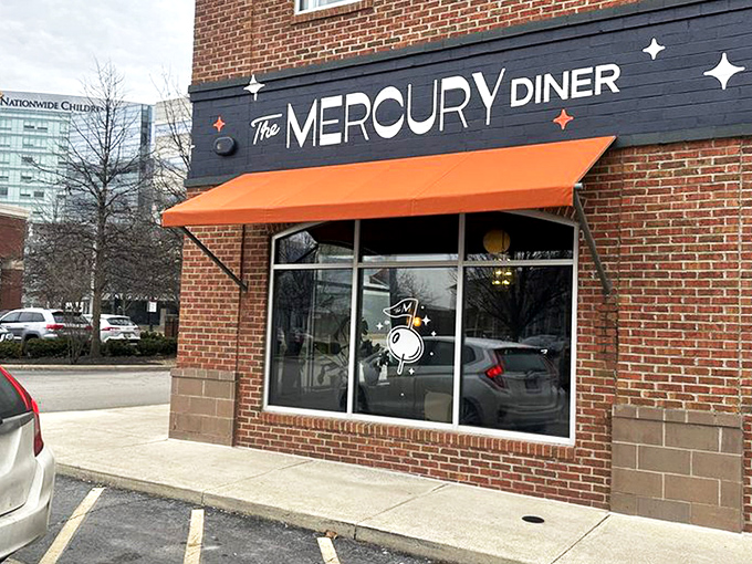 The Mercury Diner's navy blue facade with bright orange awning isn't just inviting&mdash;it's practically a bat signal for hungry Ohioans seeking comfort food nirvana.